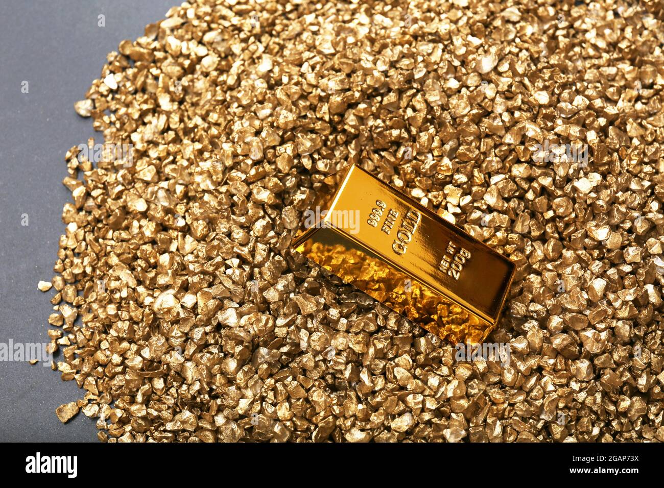 Gold bars on nugget grains background, close-up Stock Photo - Alamy