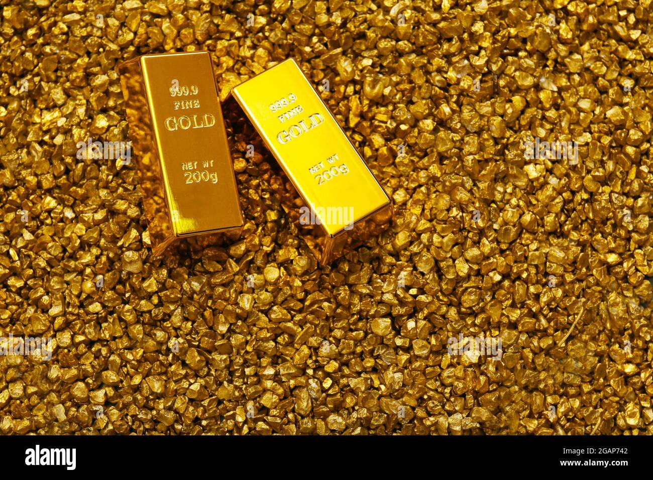 Gold bars on nugget grains background, close-up Stock Photo - Alamy