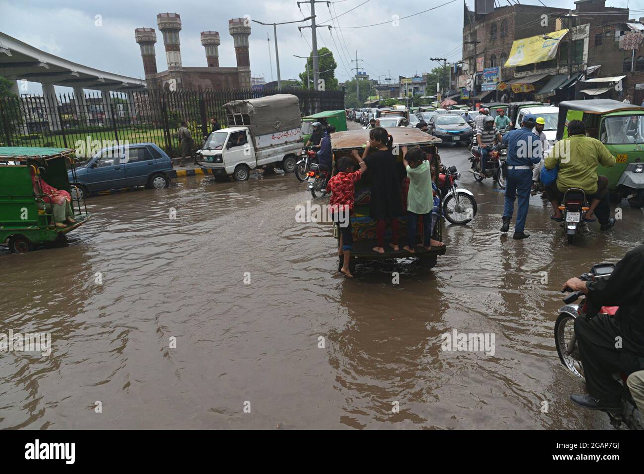 Lahore, Pakistan. 31st July, 2021. Pakistani commuters wade through a ...