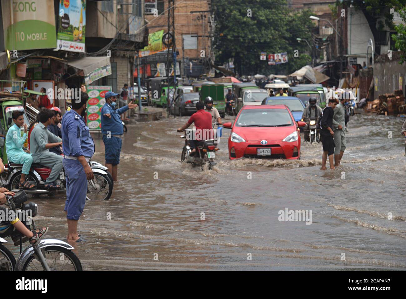 Lahore, Pakistan. 31st July, 2021. Pakistani commuters wade through a ...
