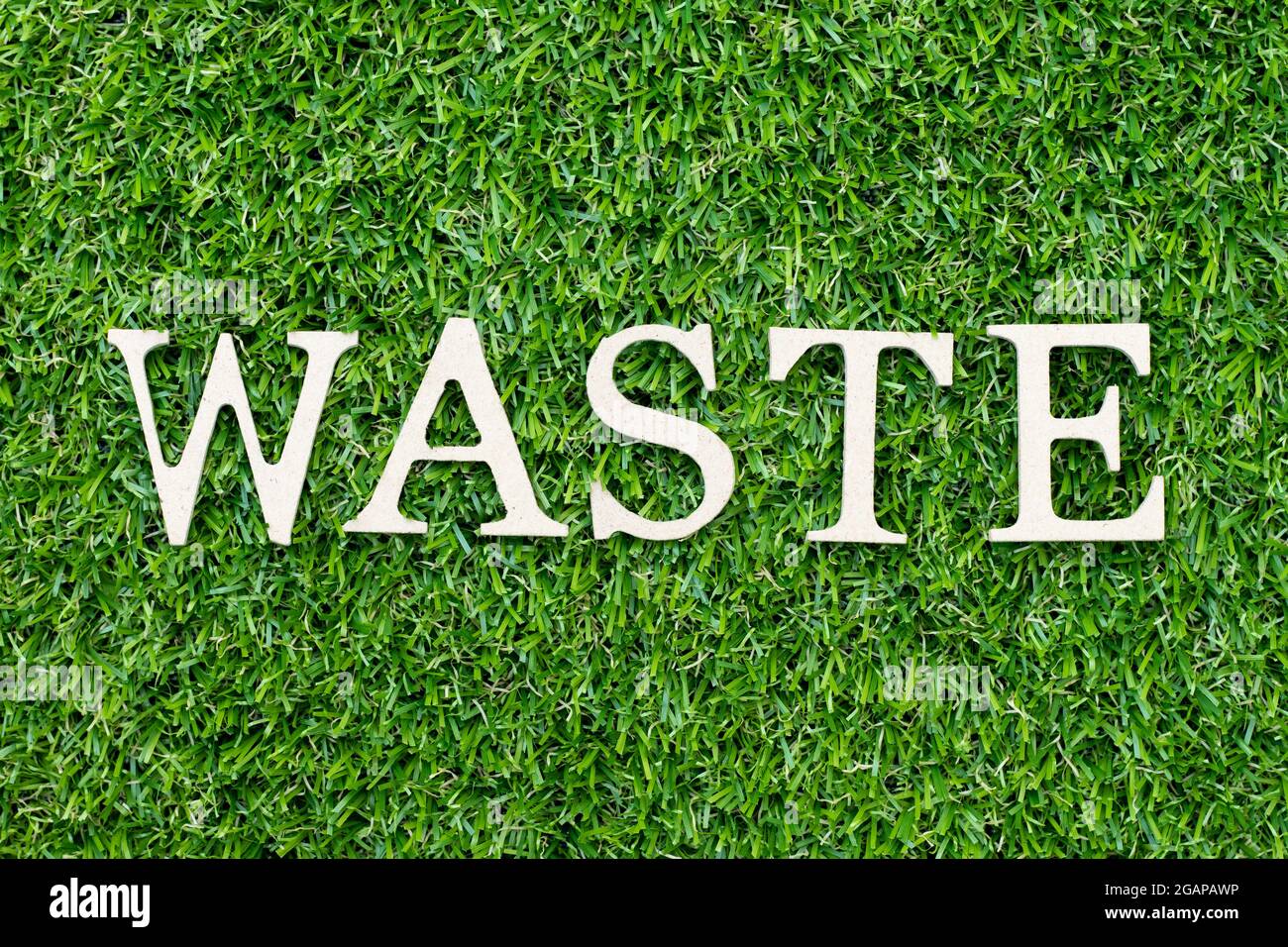 Wood alphabet letter in word waste on green grass background Stock ...
