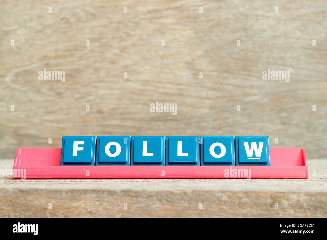 Tile alphabet letter with word follow in red color rack on wood ...