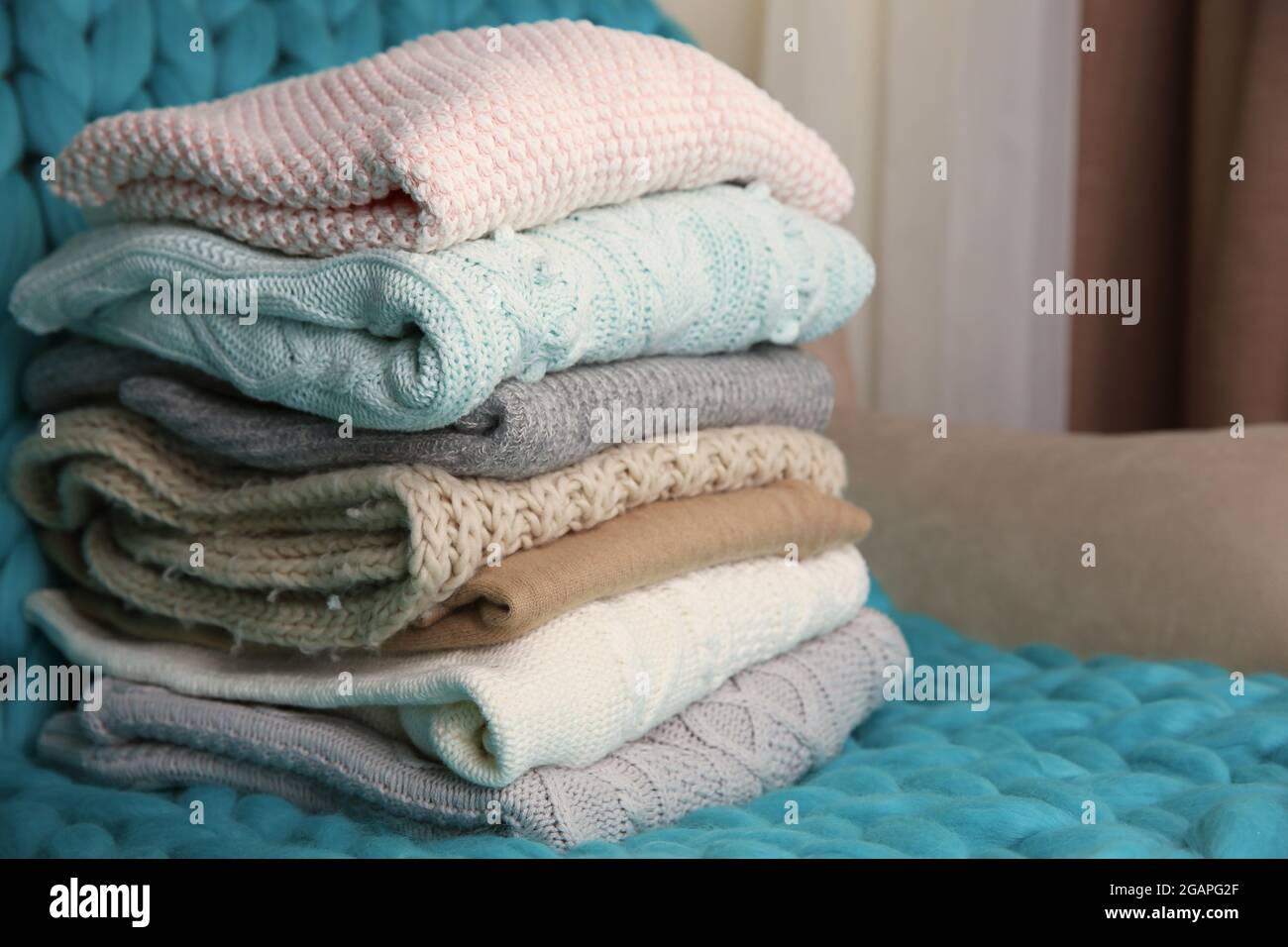 Knitted clothes on a sofa Stock Photo - Alamy