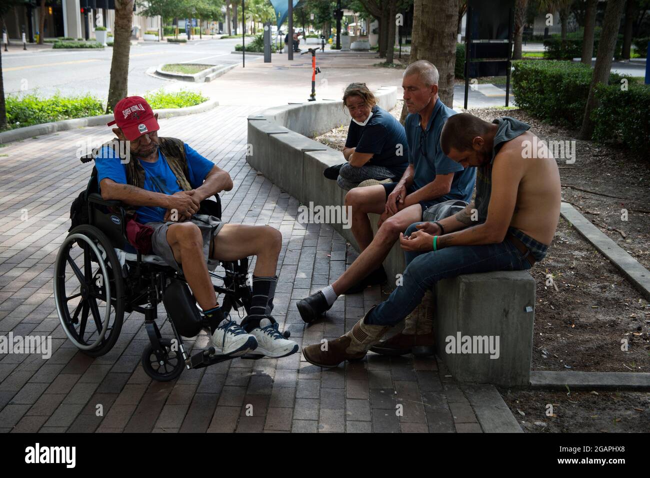 Tampa, Florida, USA. 31st July, 2021. Homeless men and women pass the ...
