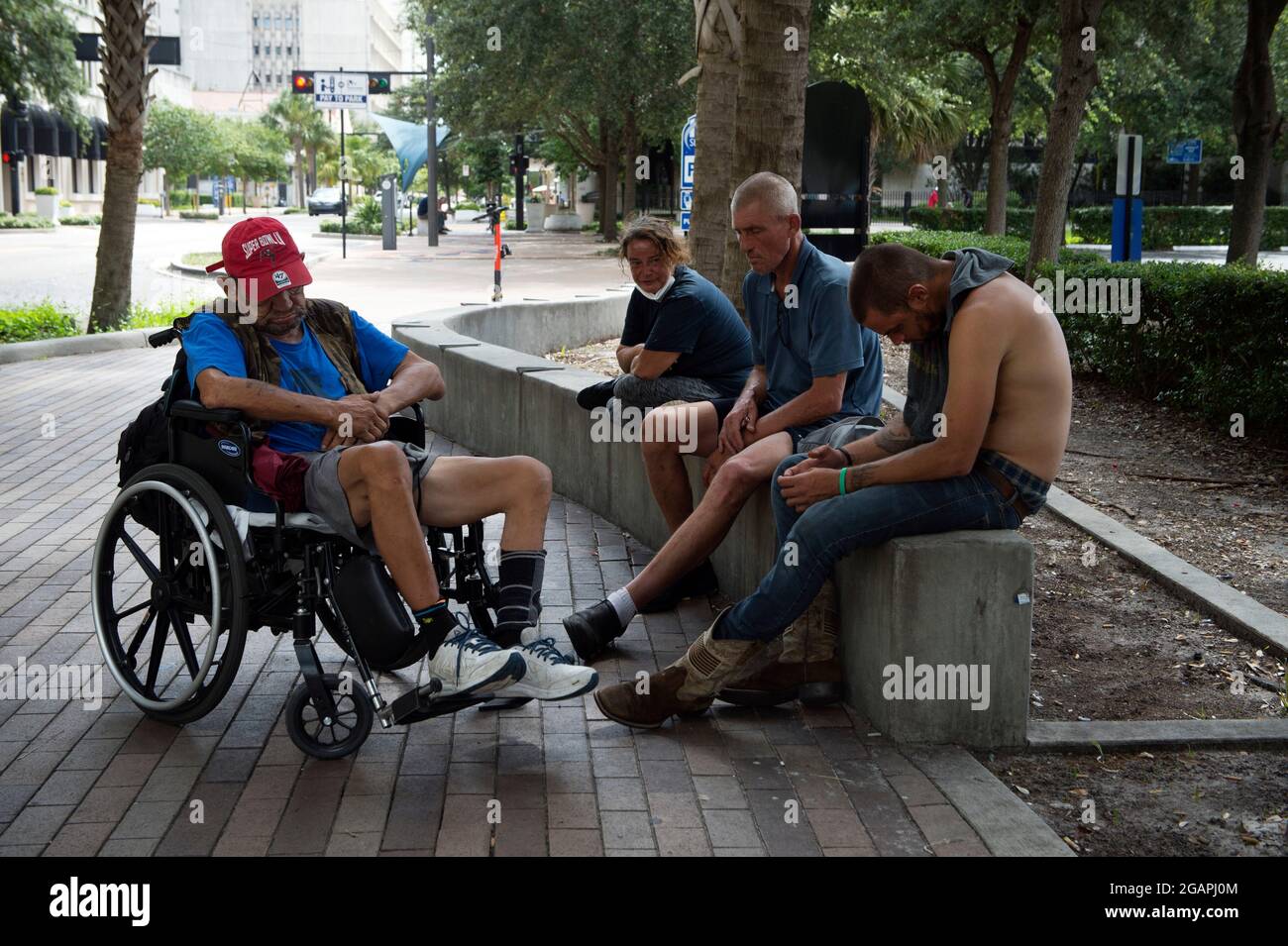 Tampa, Florida, USA. 31st July, 2021. Homeless men and women pass the ...