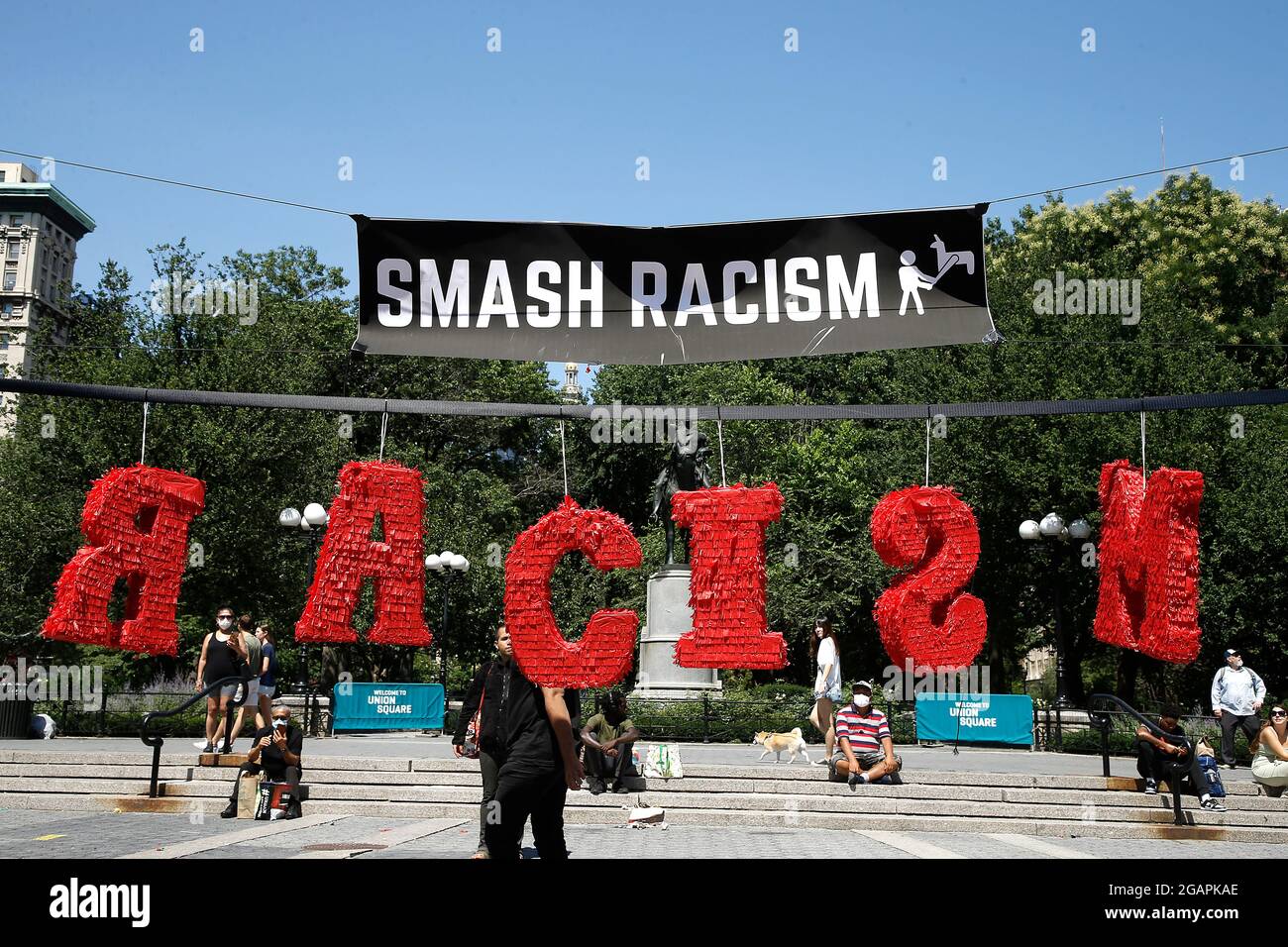 Passerby smash letters that spell rascism filled with candy with sticks ...