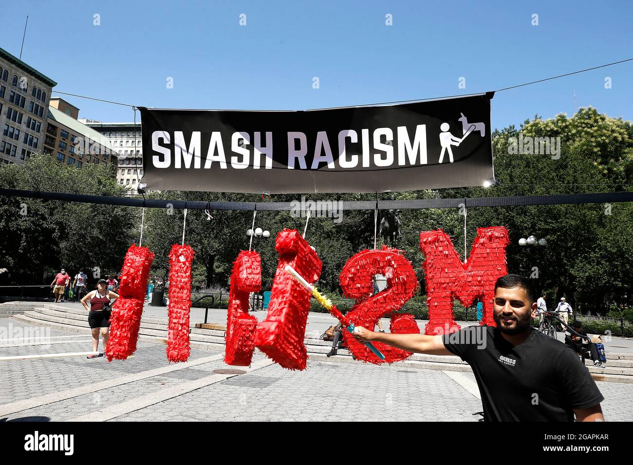 Passerby smash letters that spell rascism filled with candy with sticks ...