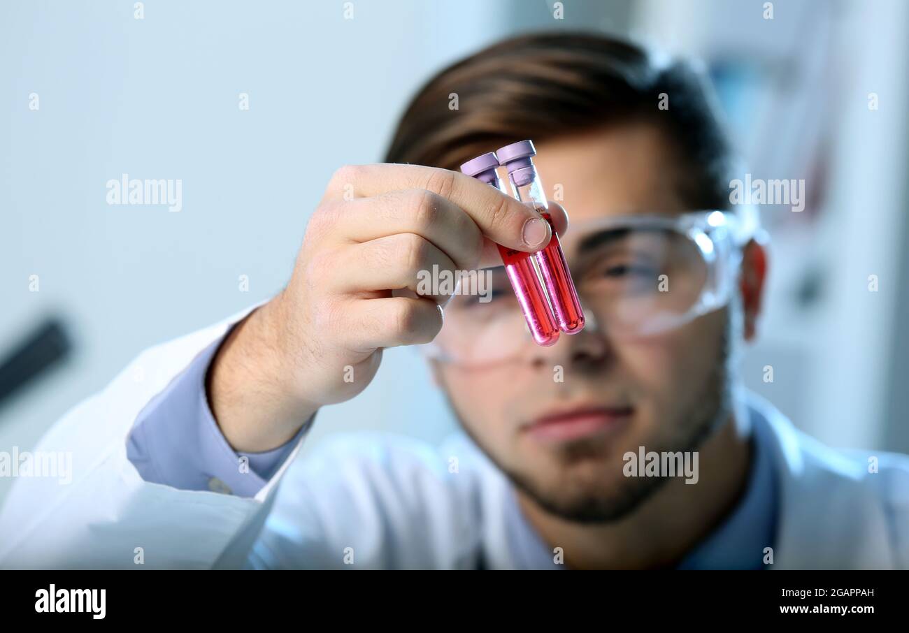 Man in laboratory checking test tubes Stock Photo - Alamy