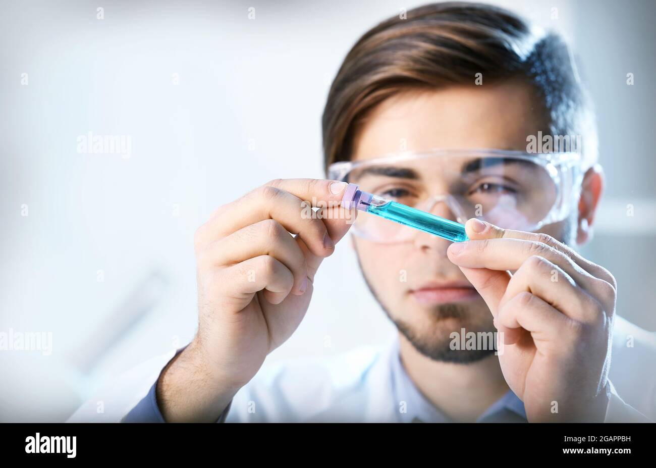 Man in laboratory checking test tubes Stock Photo - Alamy