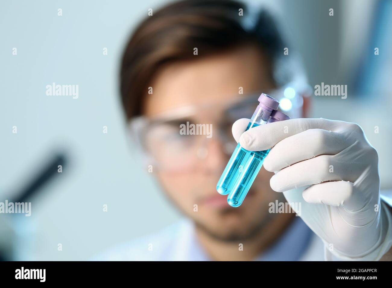 Man in laboratory checking test tubes Stock Photo - Alamy