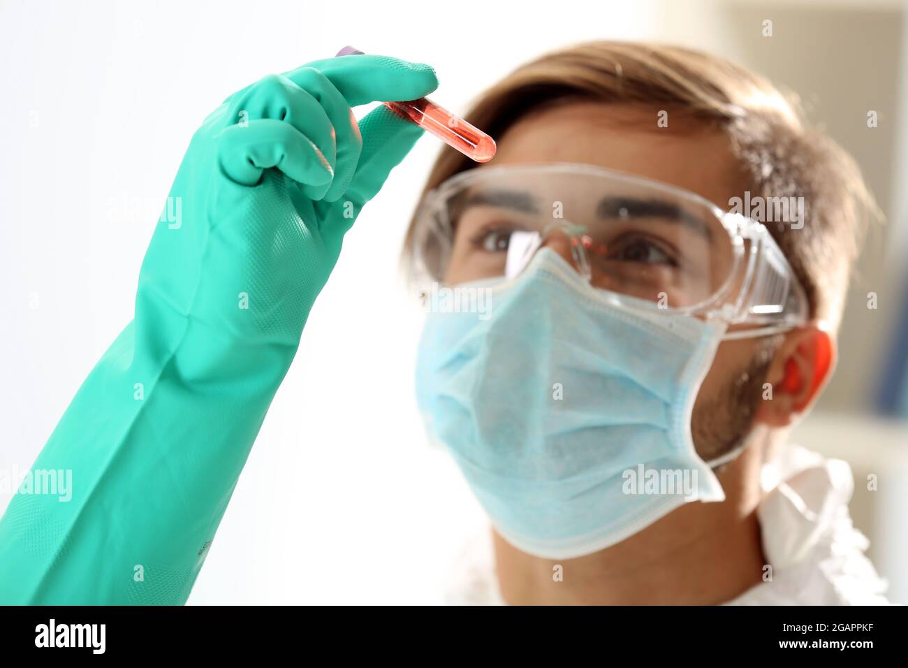 Man in laboratory checking test tubes Stock Photo - Alamy
