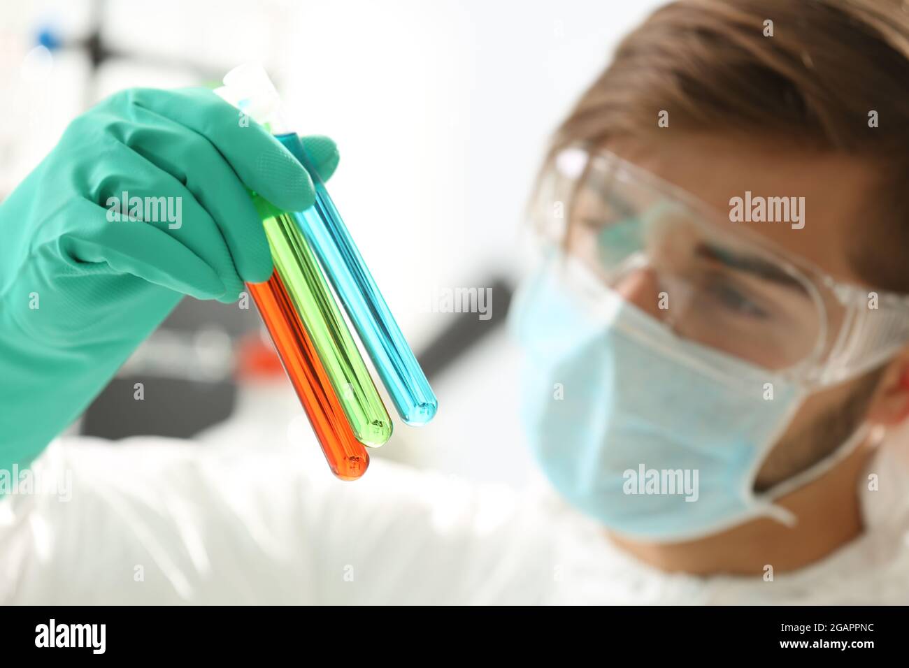 Man in laboratory checking test tubes Stock Photo - Alamy