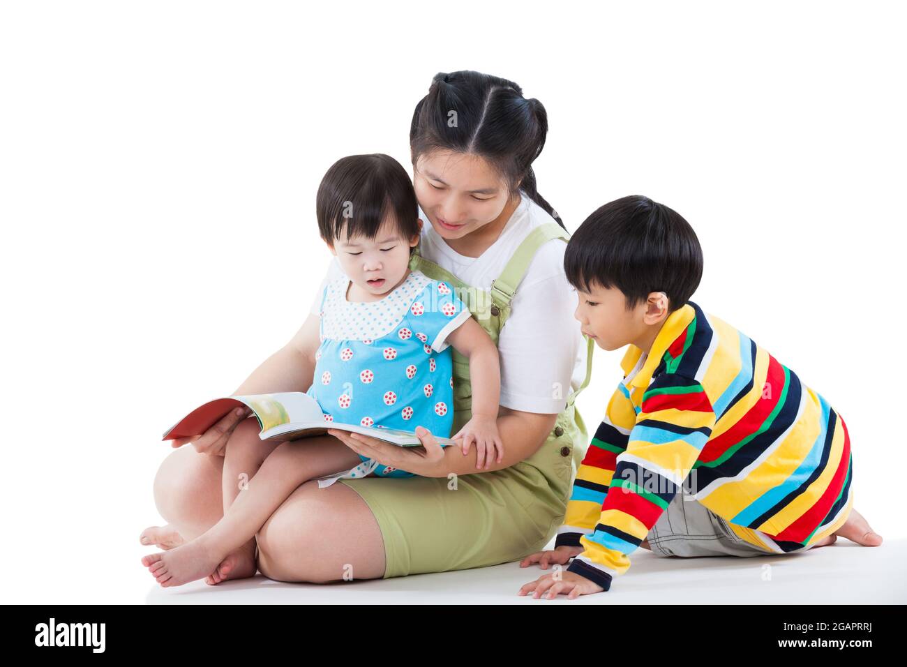 Image of cute young female with two little asian children reading a ...