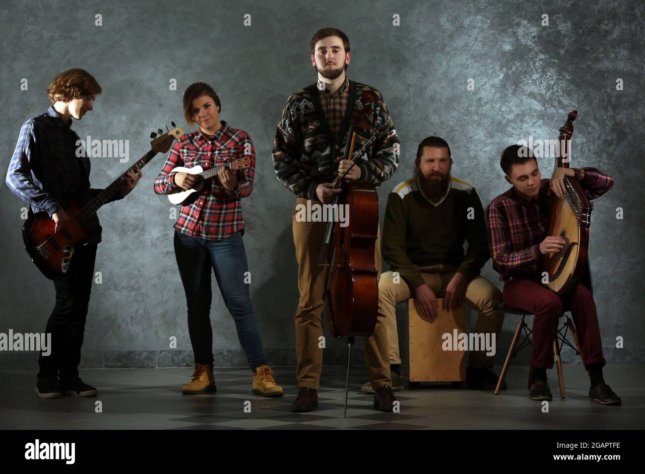Musical band on grey wall background Stock Photo - Alamy