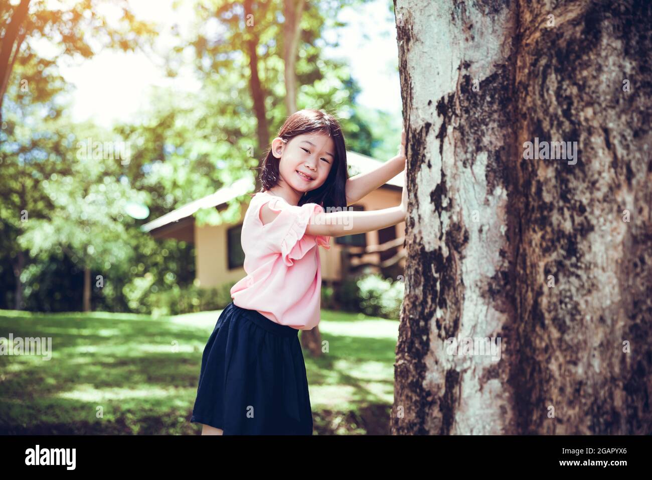 Cute little asian girl under big tree outdoor in the park Stock Photo ...