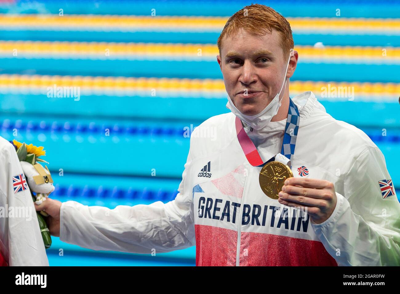 TOKYO, JAPAN - JULY 27: Tom Dean of Great Britain shows the gold medal ...