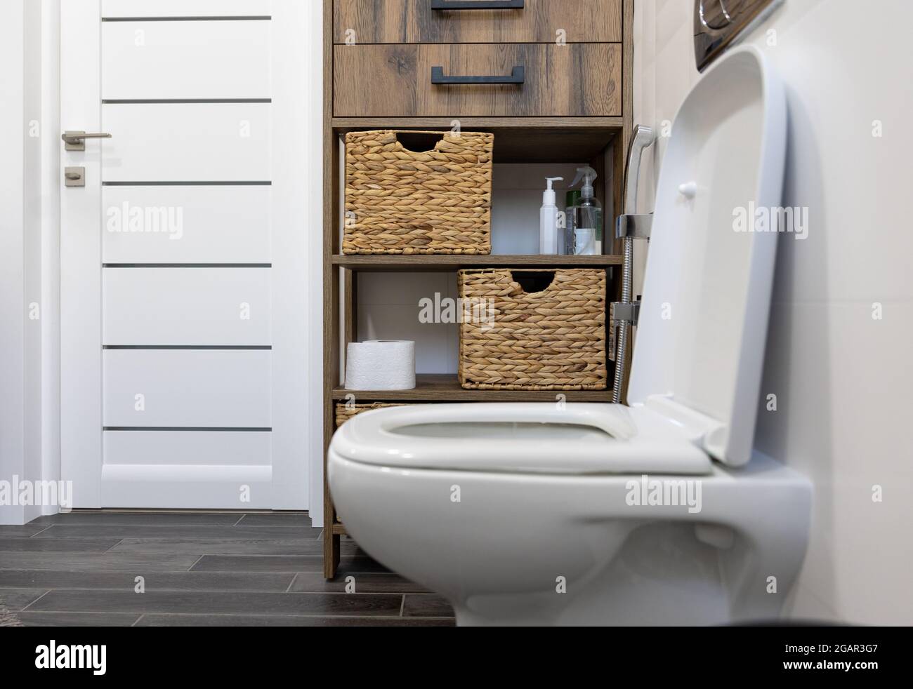 White bathroom with a toilet and straw details Stock Photo - Alamy