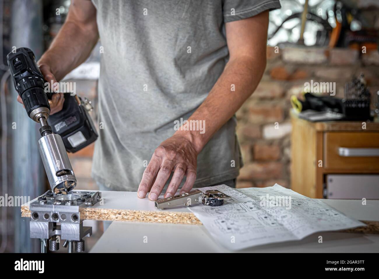 The carpenter works with a professional precision drilling tool Stock ...