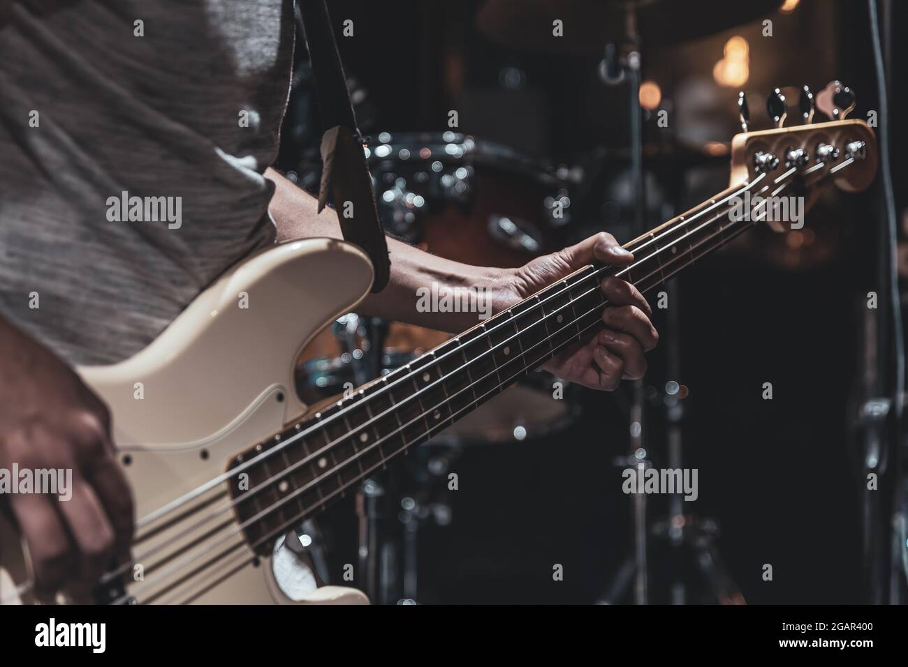Close-up of a bass guitar in the hands of a musician in the process of ...
