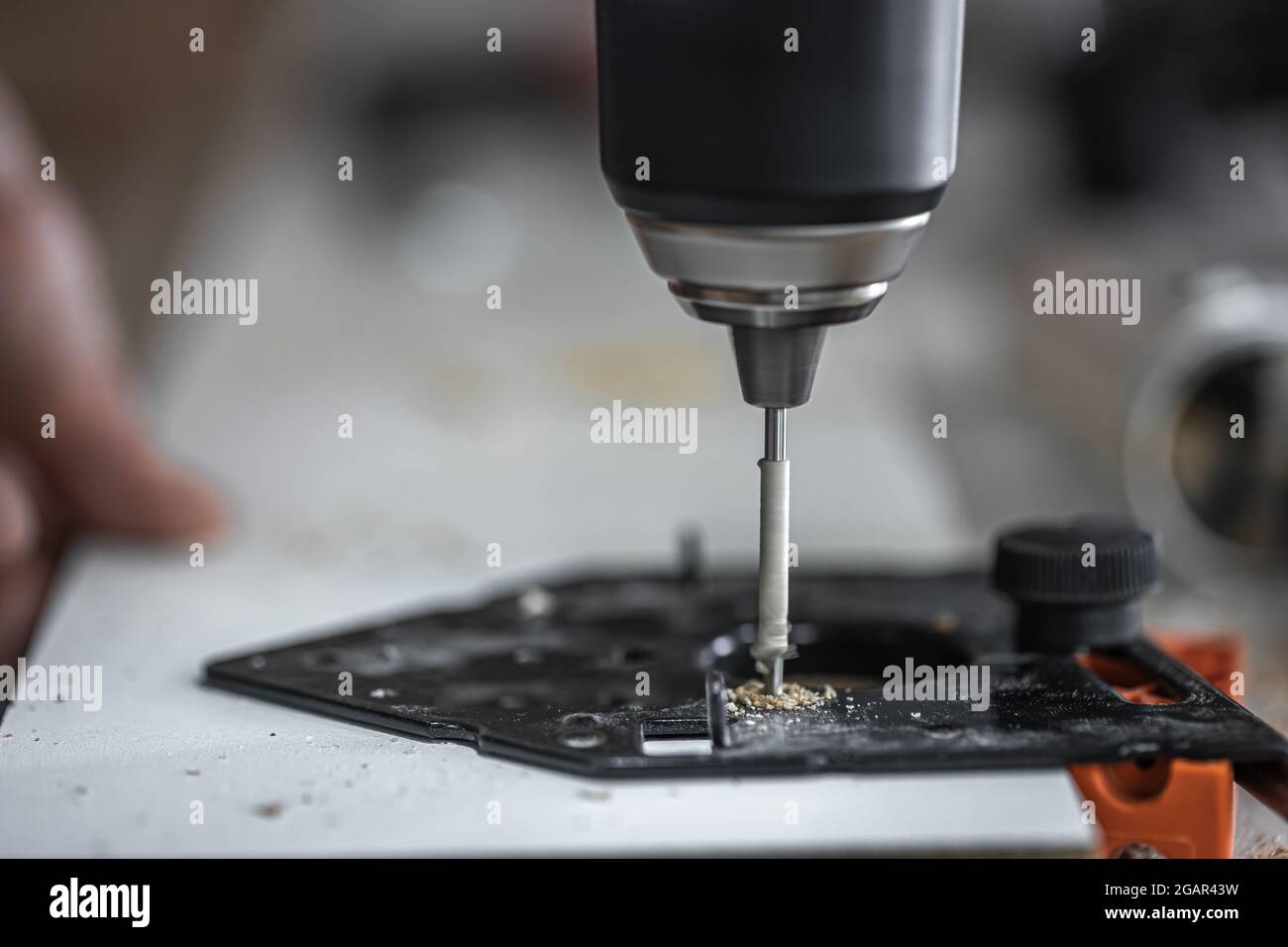 Screwing a self-tapping screw into a metal fastening hole on a wood ...