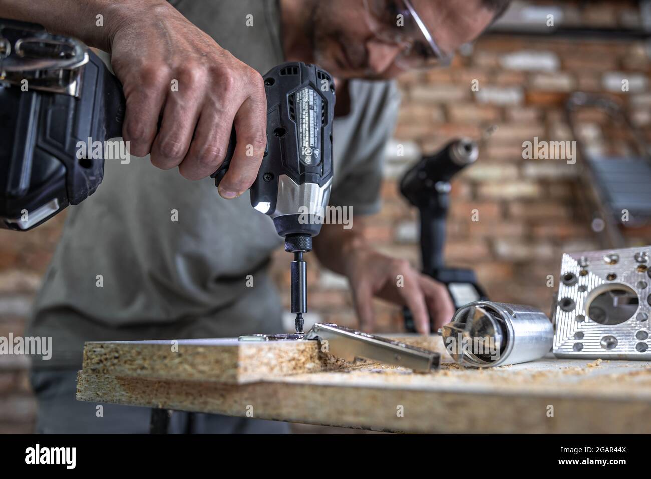 Screwing a self-tapping screw into a metal fastening hole on a wood ...