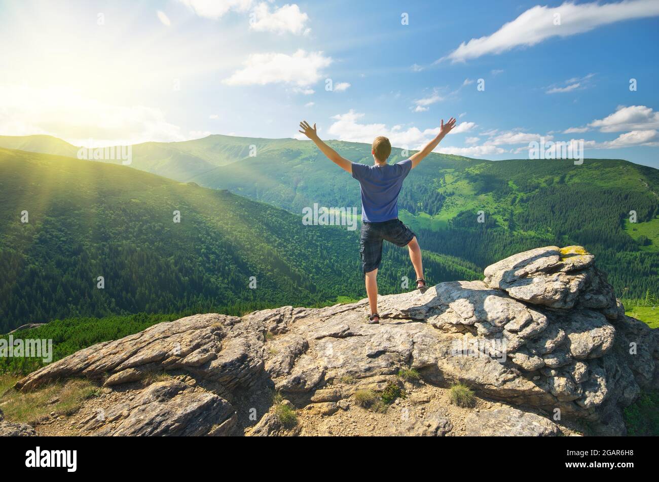 Man on peak of mountain reach to the sun. Emotional scene Stock Photo ...