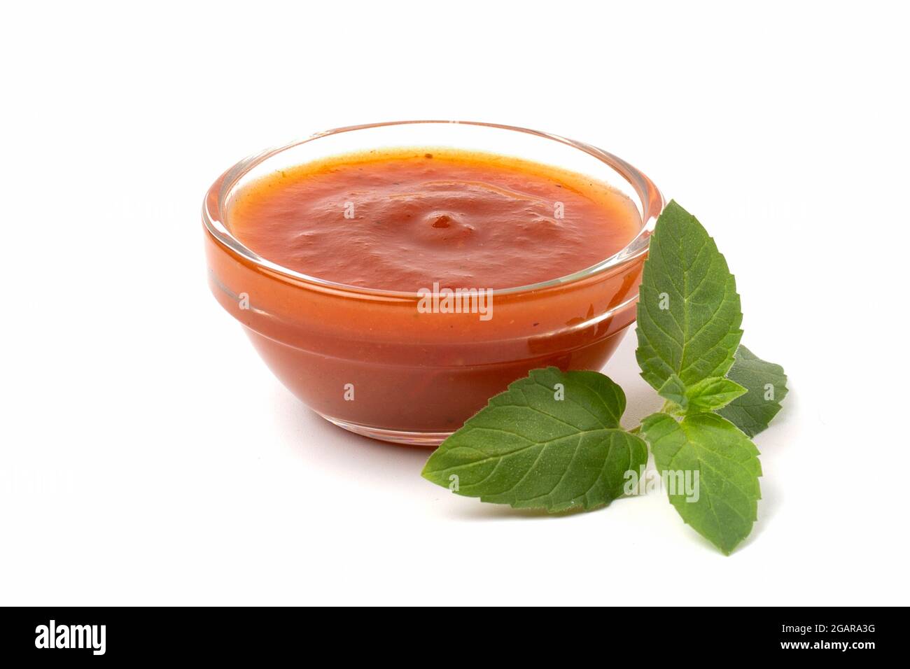 Bowl of tomato sauce with green mint leaf, isolated on white background ...