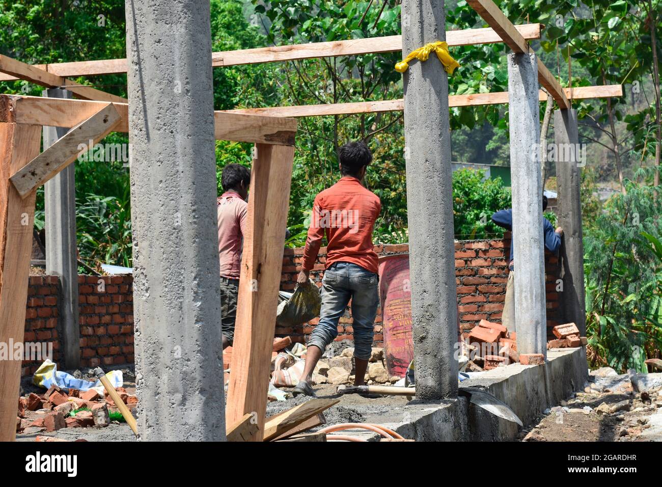Man at work carrying sand on the construction site Stock Photo - Alamy
