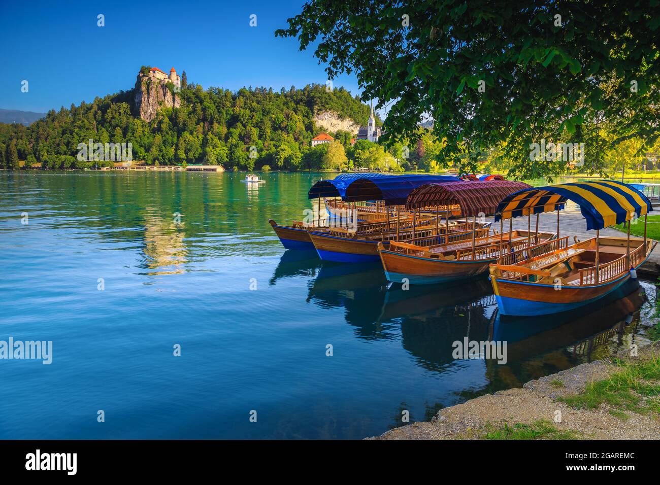 Traditional touristic wooden Pletna boat moored on the waterfront ...