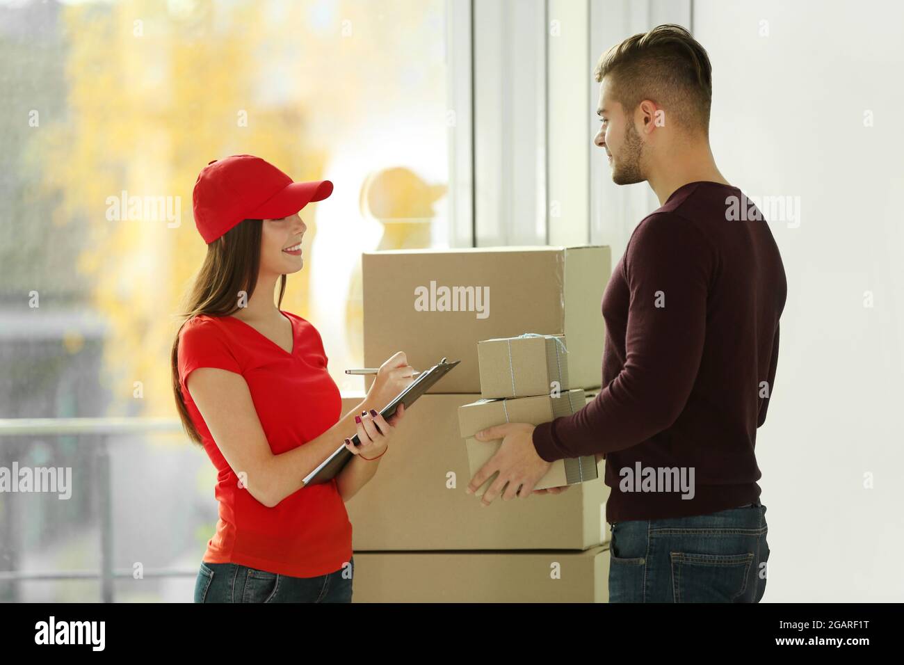 Young man receiving parcel Stock Photo - Alamy