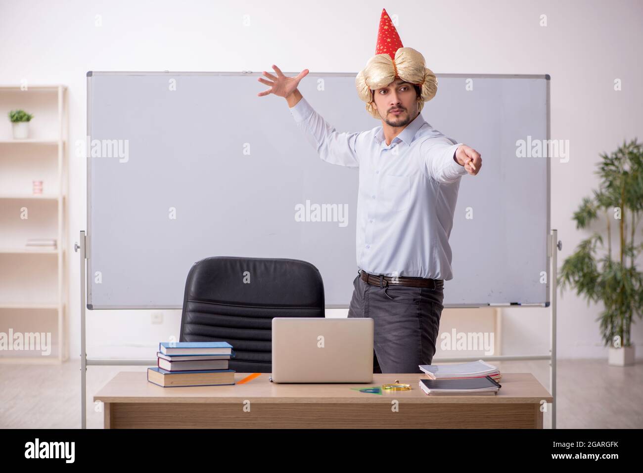 Funny young teacher magician in the classroom Stock Photo - Alamy