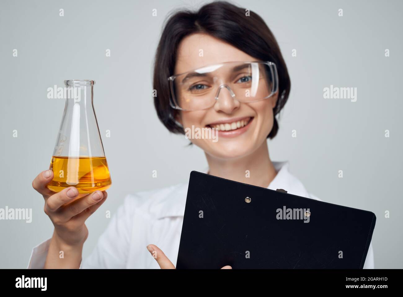 Cheerful woman laboratory assistant science research chemical solution ...