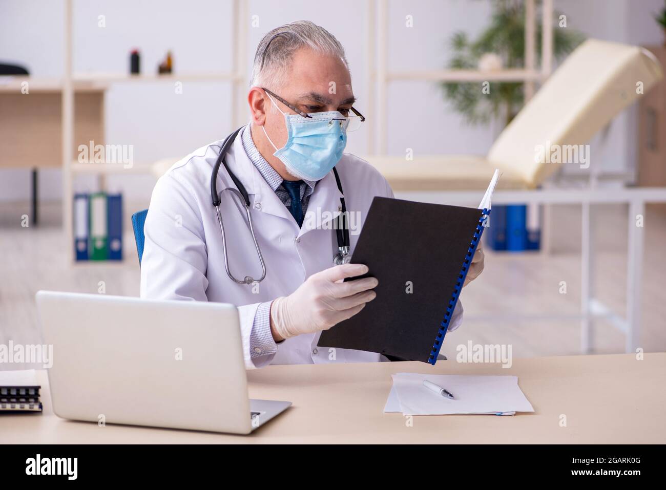 Old doctor working in the clinic Stock Photo - Alamy