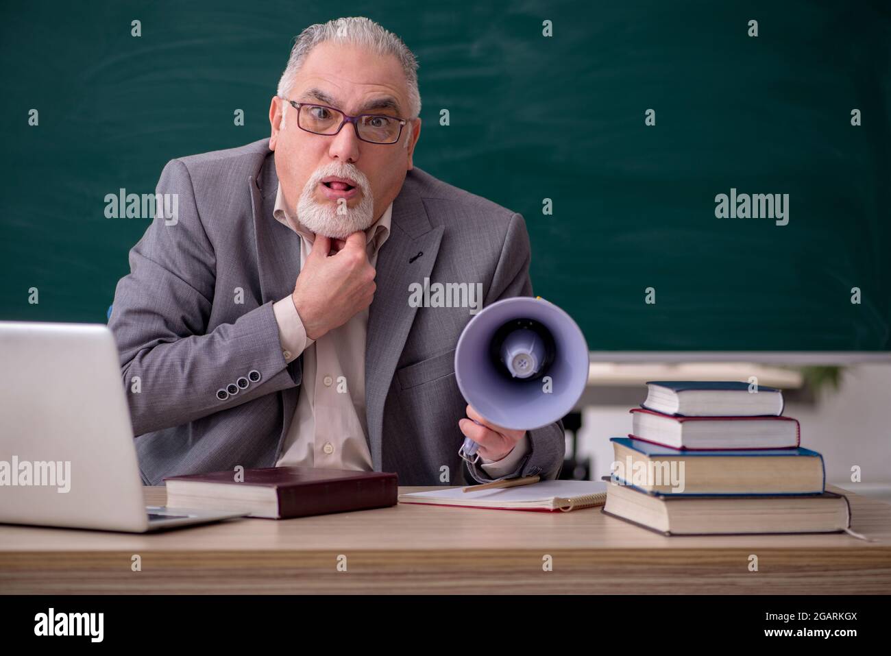 Old teacher holding megaphone in front of blackboard Stock Photo - Alamy