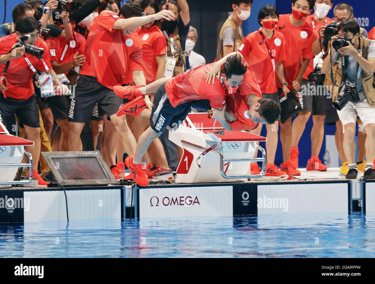 Japanese swimmers Daiya Seto (C, L) and Kosuke Hagino jump into the ...
