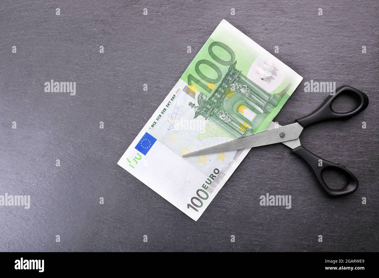 Concept of spending money - scissors cut money on black background ...