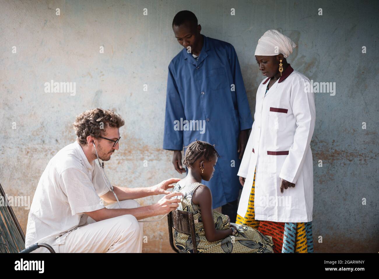 IN this image, two African physicians observing a young white doctor ...