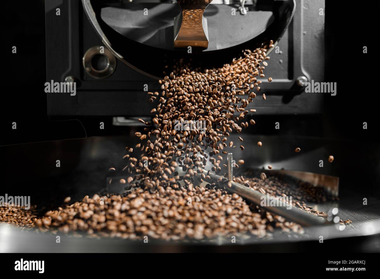 Coffee processing. Roastery, roasting machine and fresh beans Stock ...