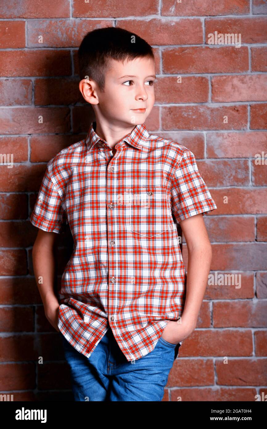 Cute little boy on brick wall background. Kids fashion concept Stock ...