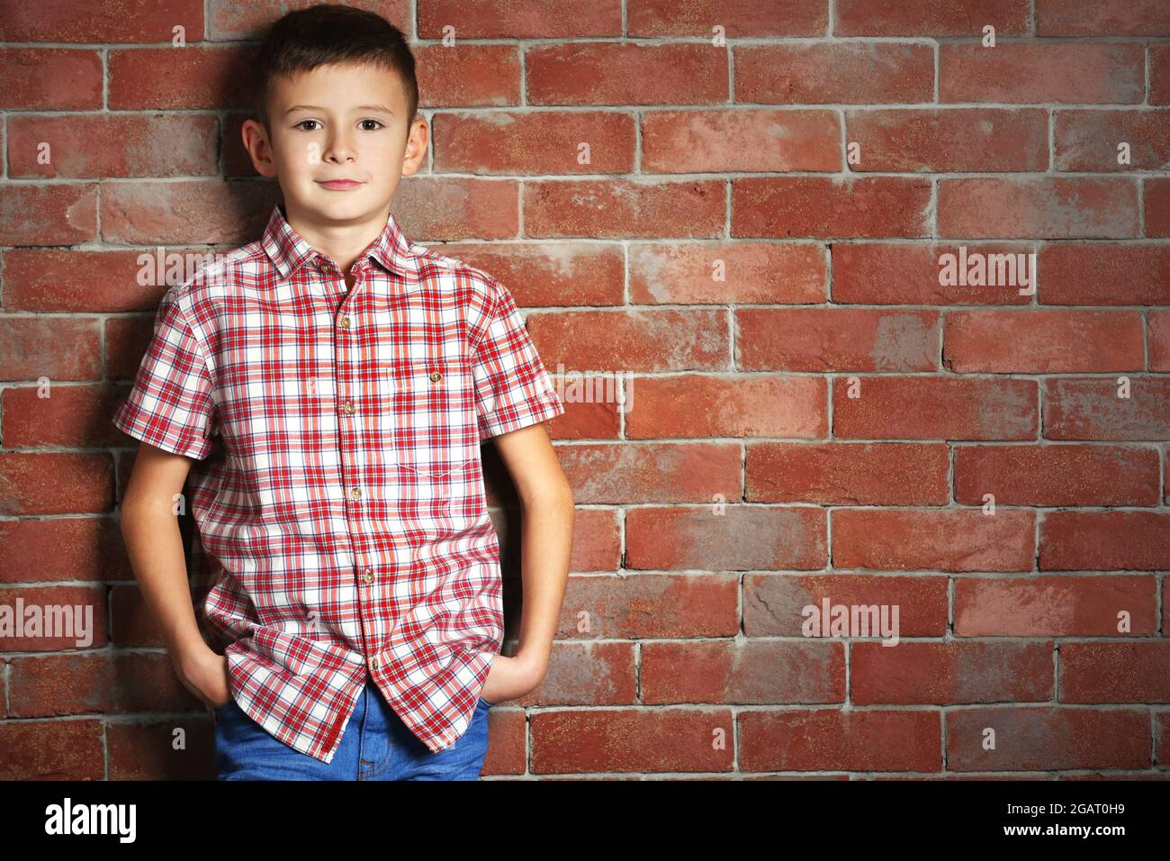 Cute little boy on brick wall background. Kids fashion concept Stock ...