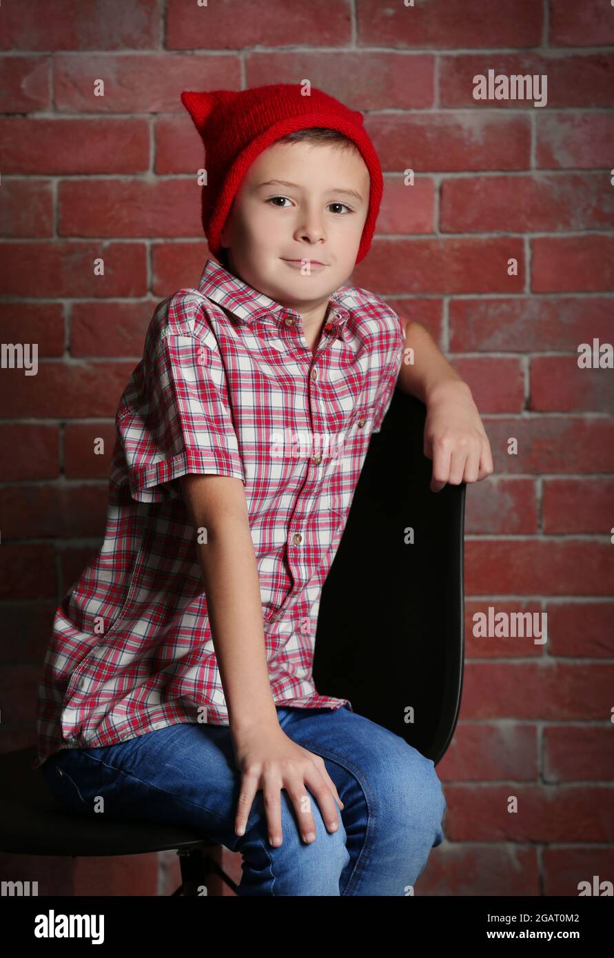 Cute little boy on brick wall background. Kids fashion concept Stock ...