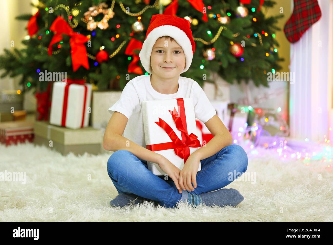 Funny boy with gift boxes and Christmas tree on background Stock Photo ...