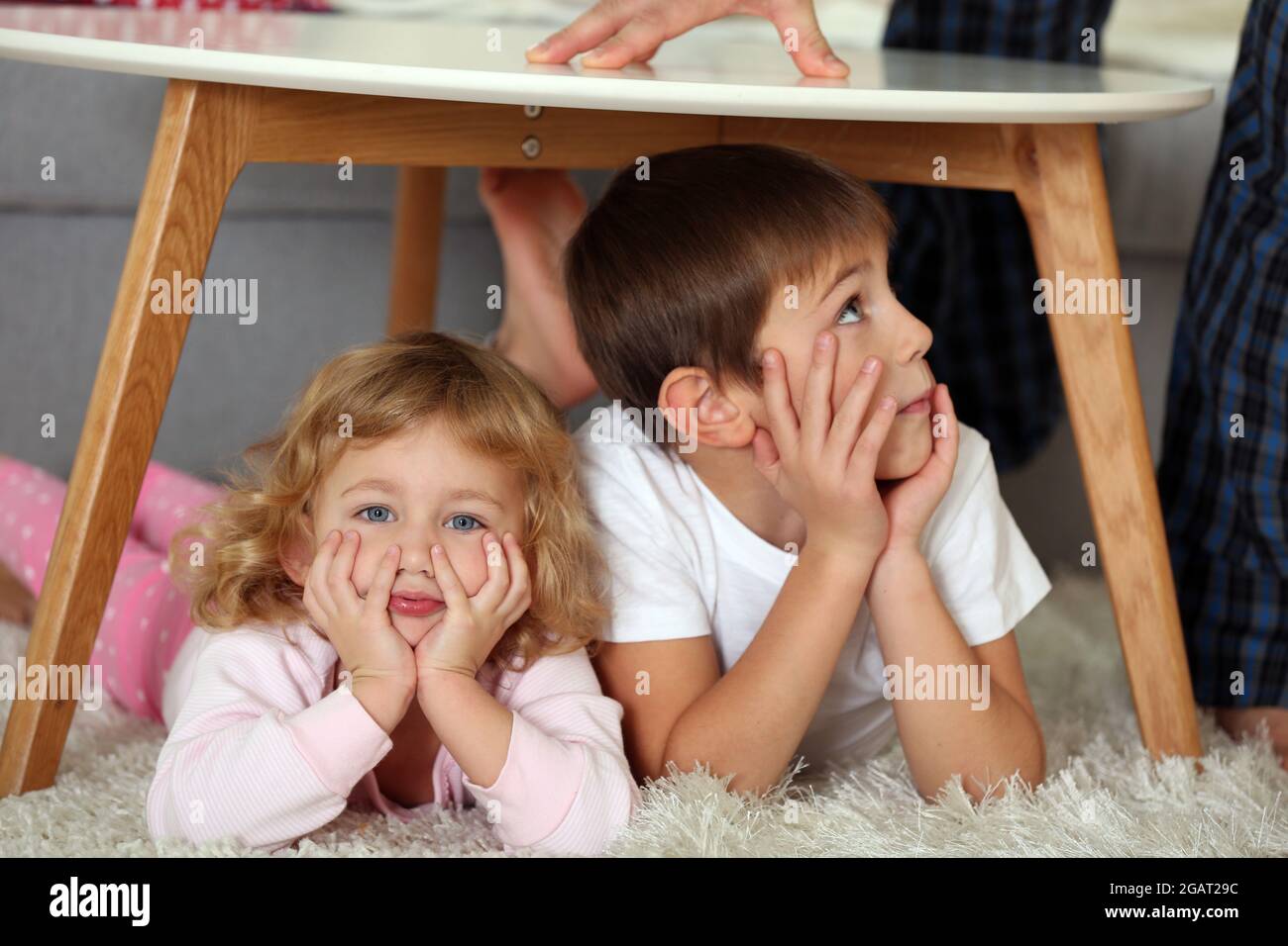 Boy hiding under table hi-res stock photography and images - Alamy