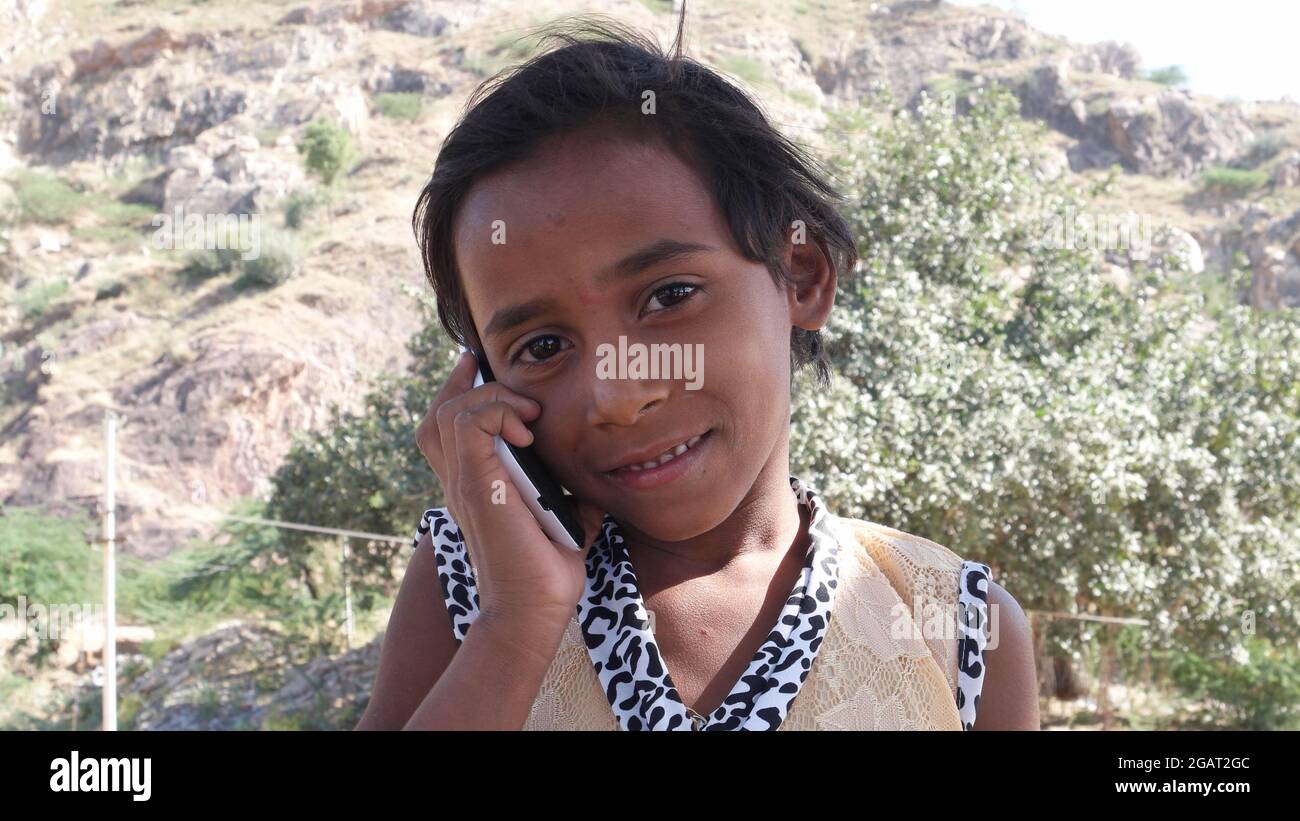 An Indian kid talking on the phone and smiling Stock Photo - Alamy