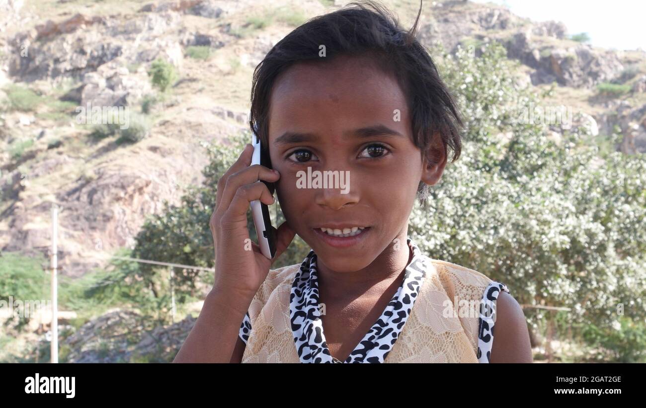 An Indian kid talking on the phone and smiling Stock Photo - Alamy
