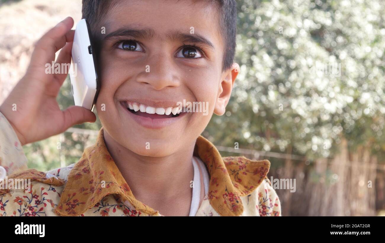 An Indian kid talking on the phone and smiling Stock Photo - Alamy