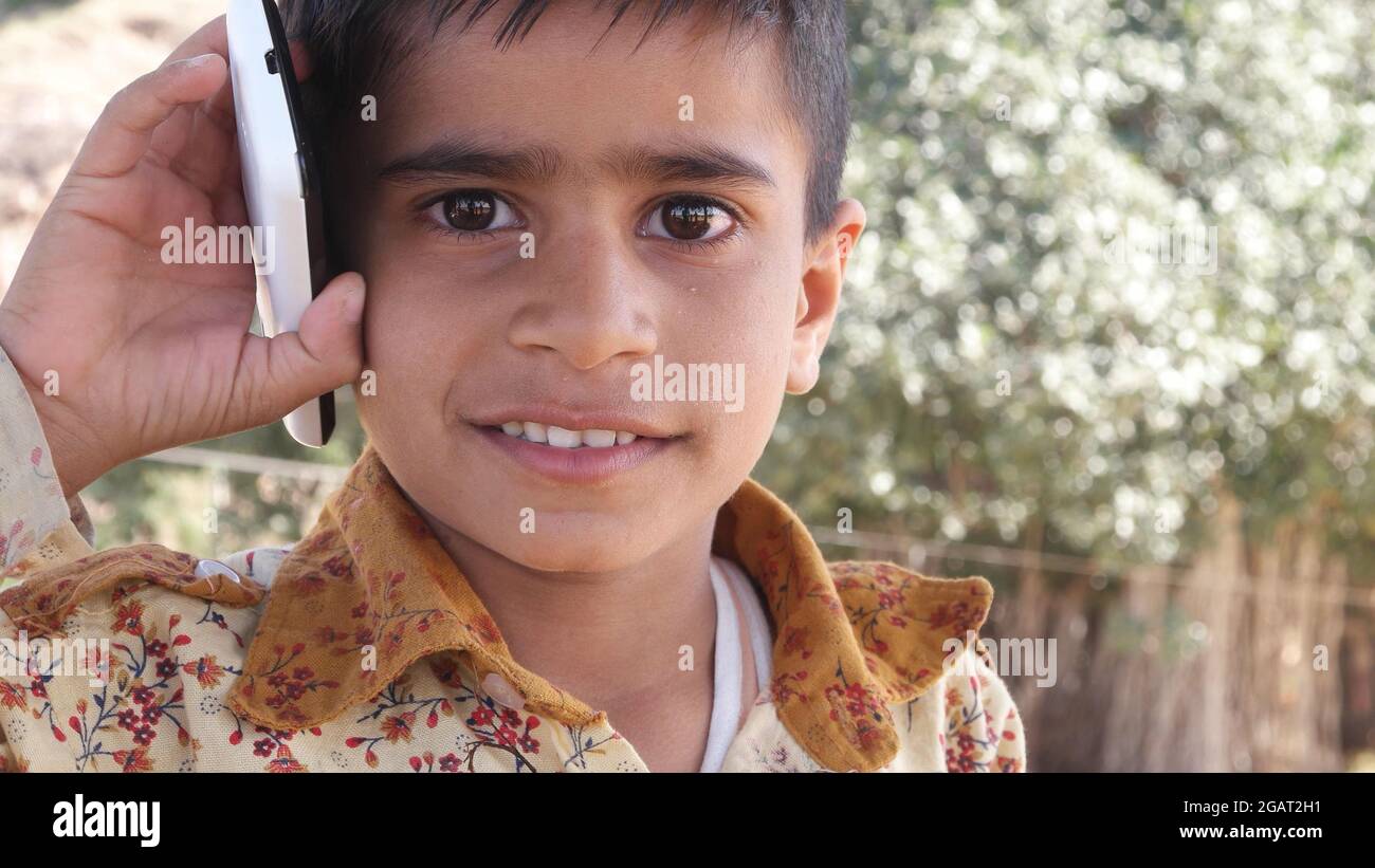 An Indian kid talking on the phone and smiling Stock Photo - Alamy