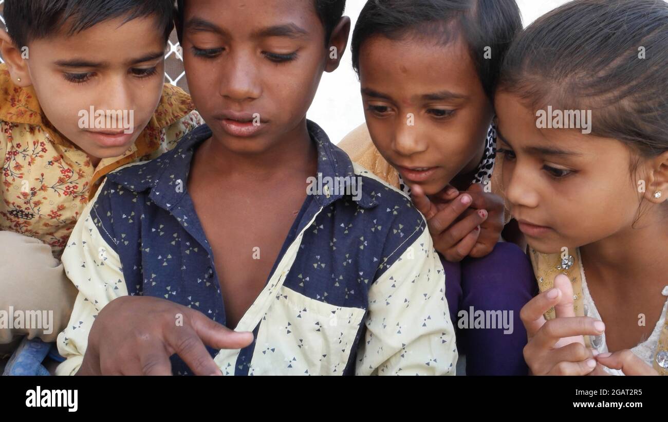 A group of Indian children looking at the phone Stock Photo - Alamy