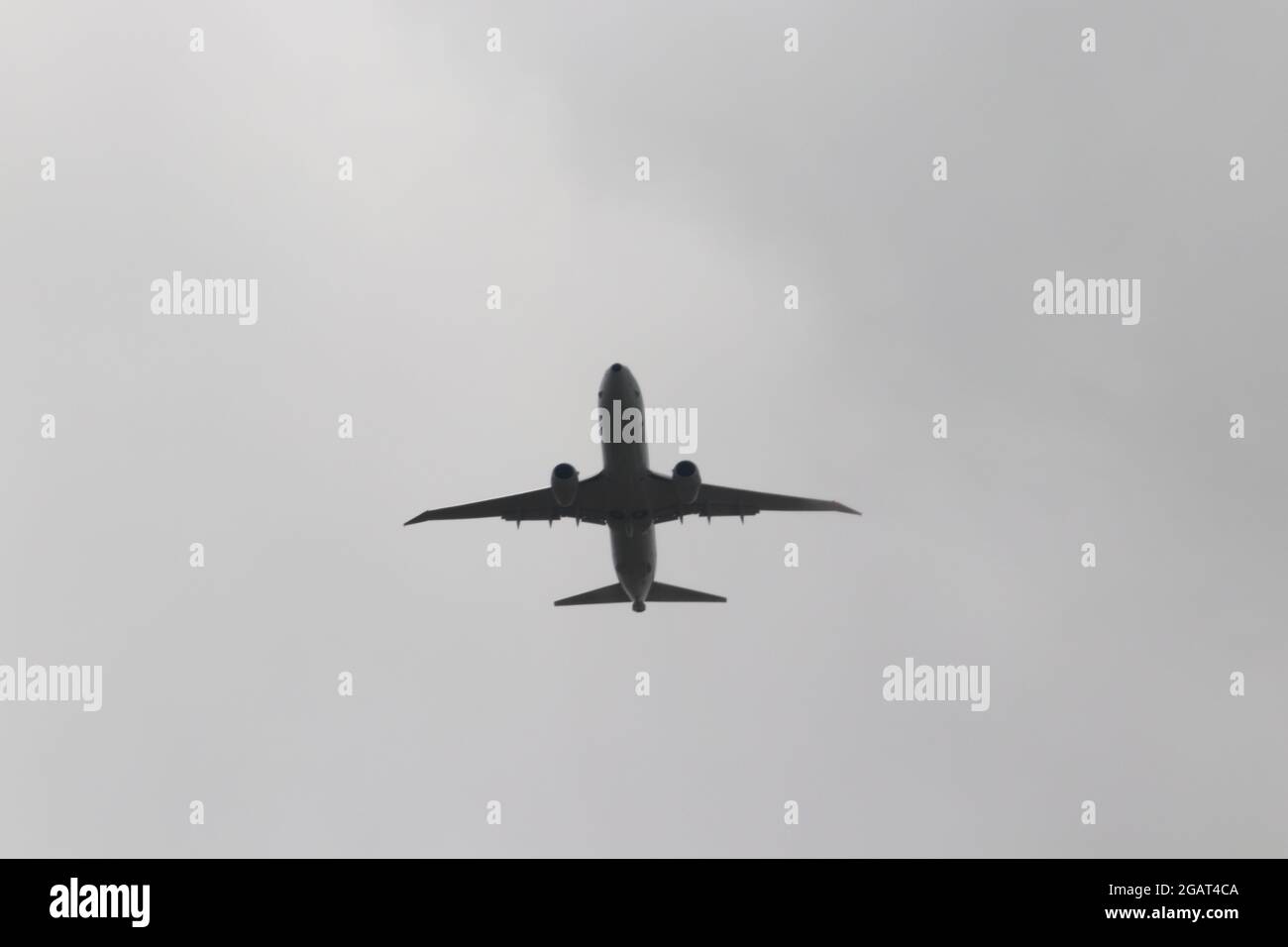 Plane disappearing into low cloud Stock Photo - Alamy