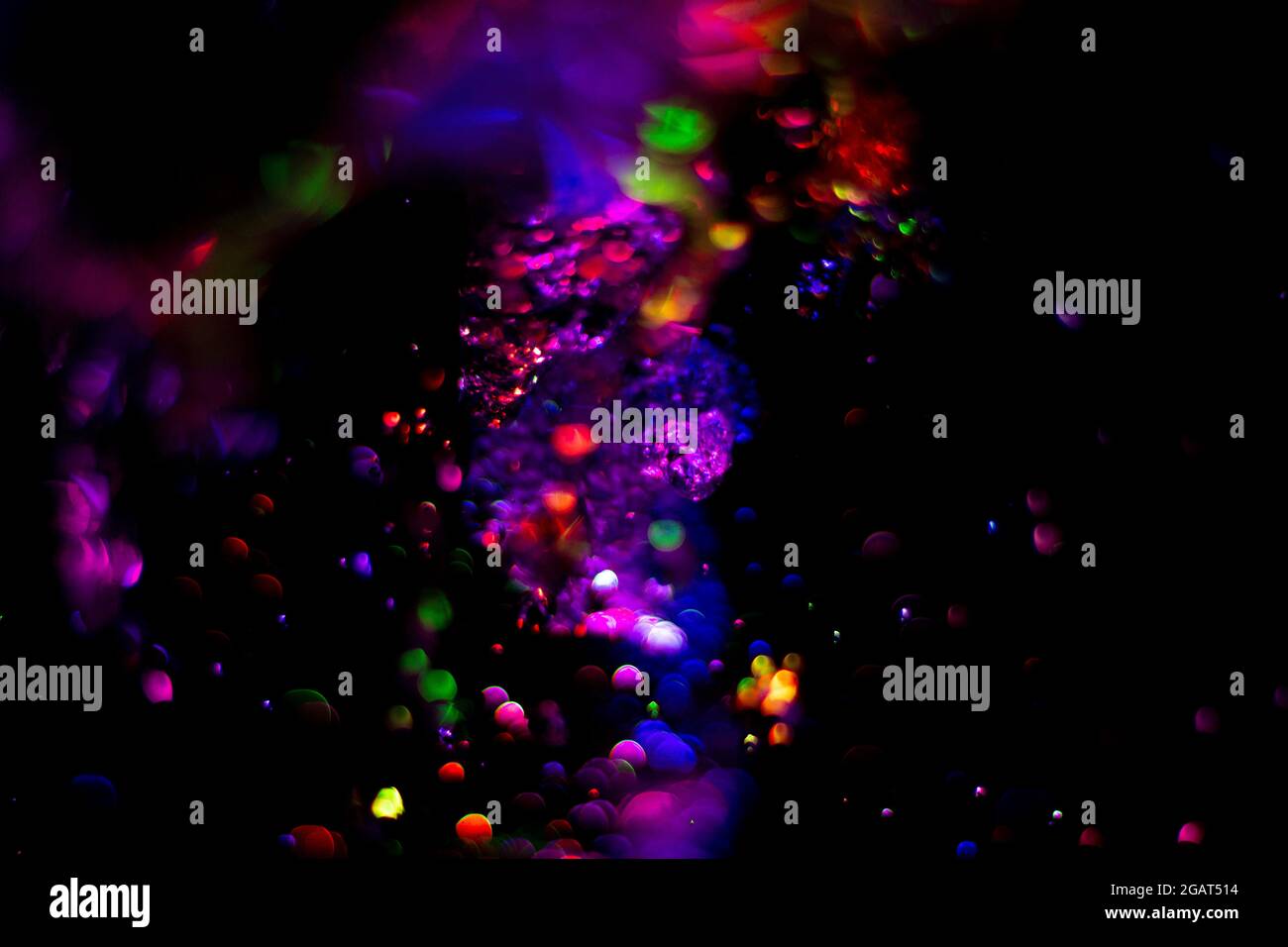 Colored water texture. Splashes of water lit in different colors. Close ...